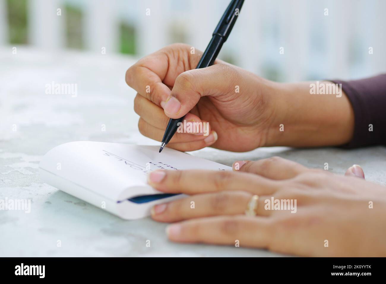 women hand writing on notepad sitting on outdoor Stock Photo - Alamy