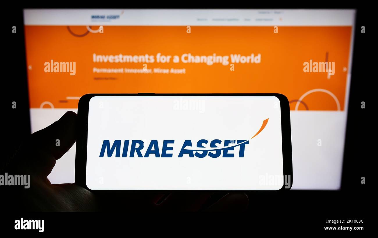 Person holding smartphone with logo of South Korean company Mirae Asset Financial Group on ...