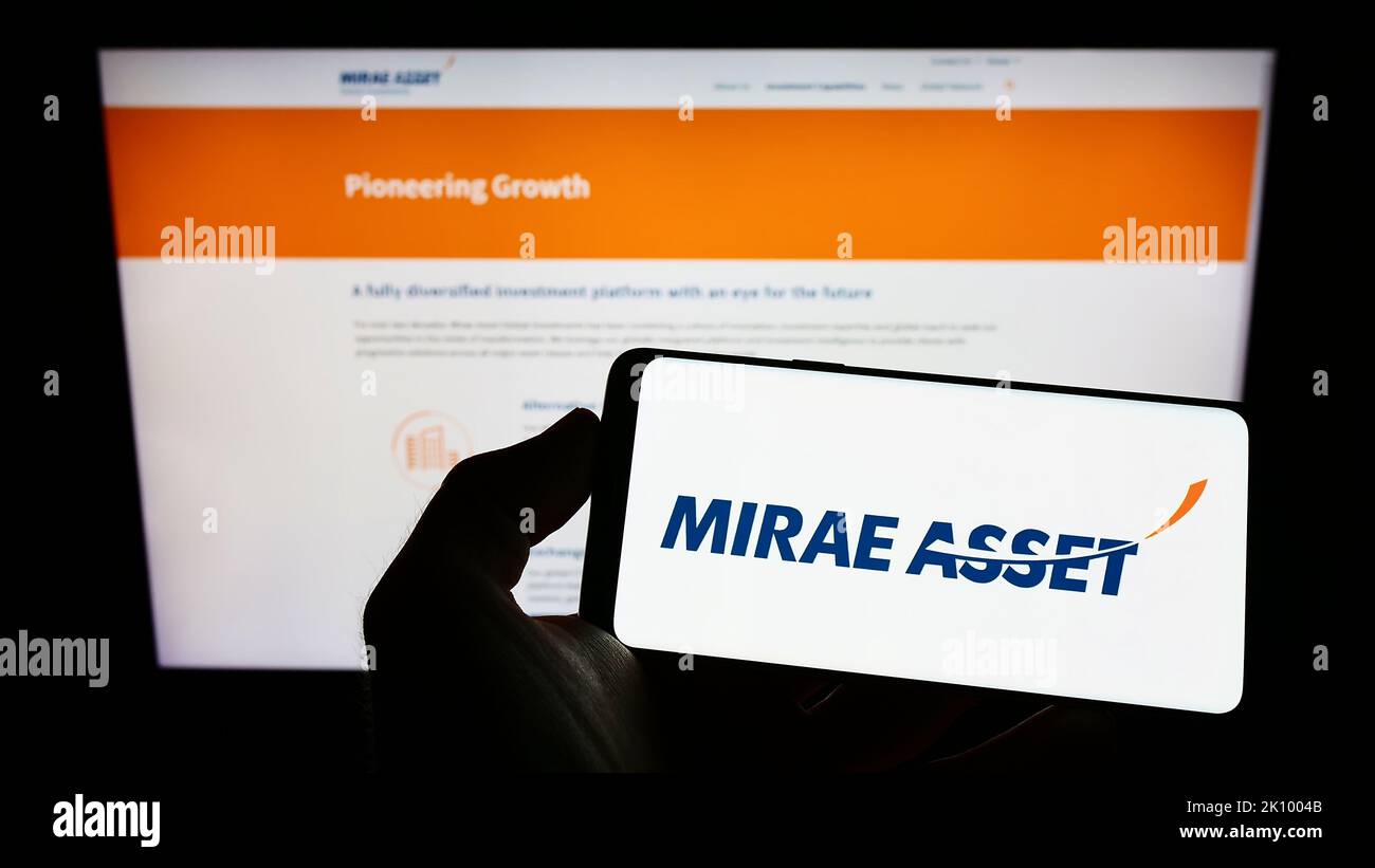 Person holding cellphone with logo of South Korean company Mirae Asset ...