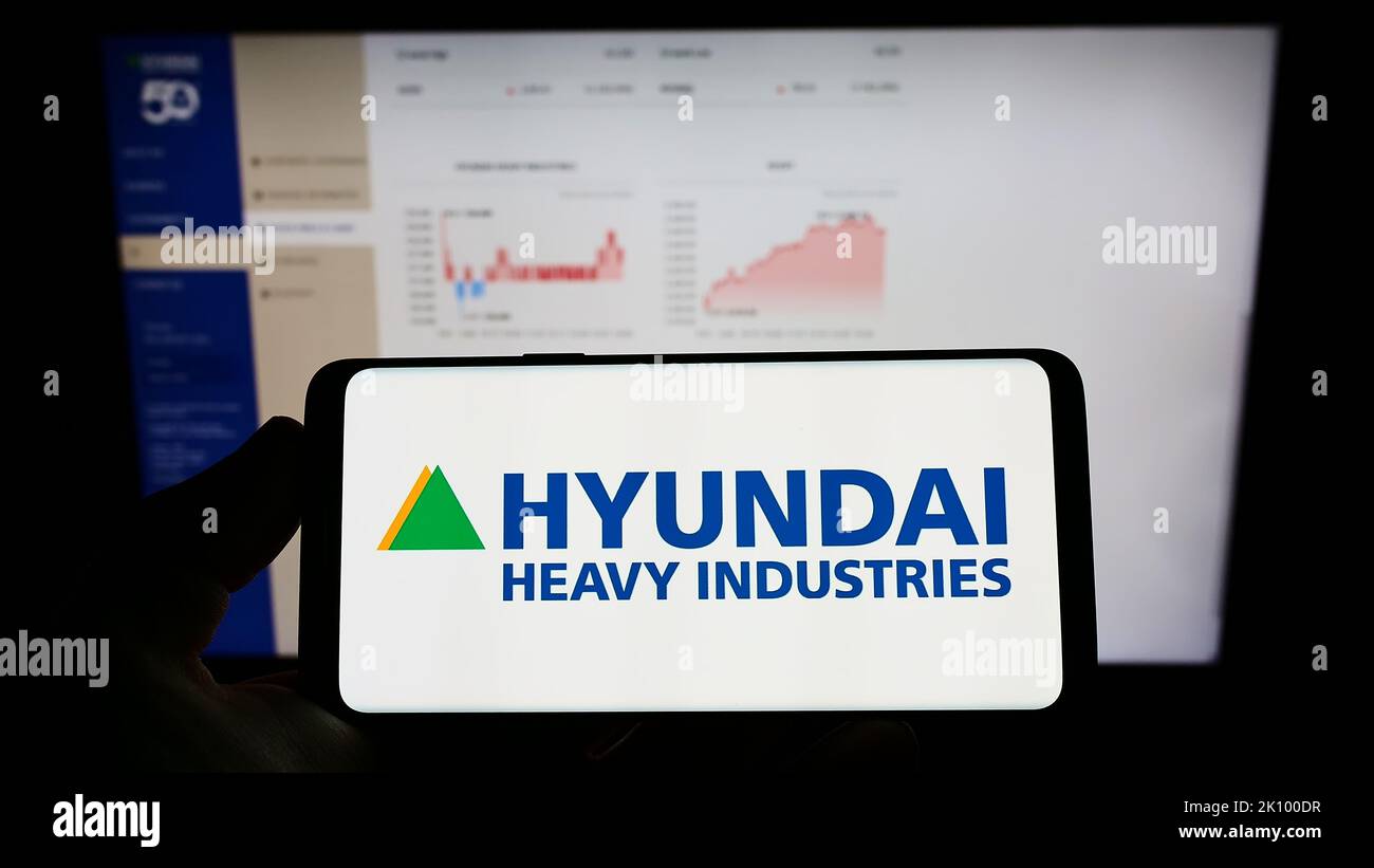 Person holding mobile phone with logo of company Hyundai Heavy ...