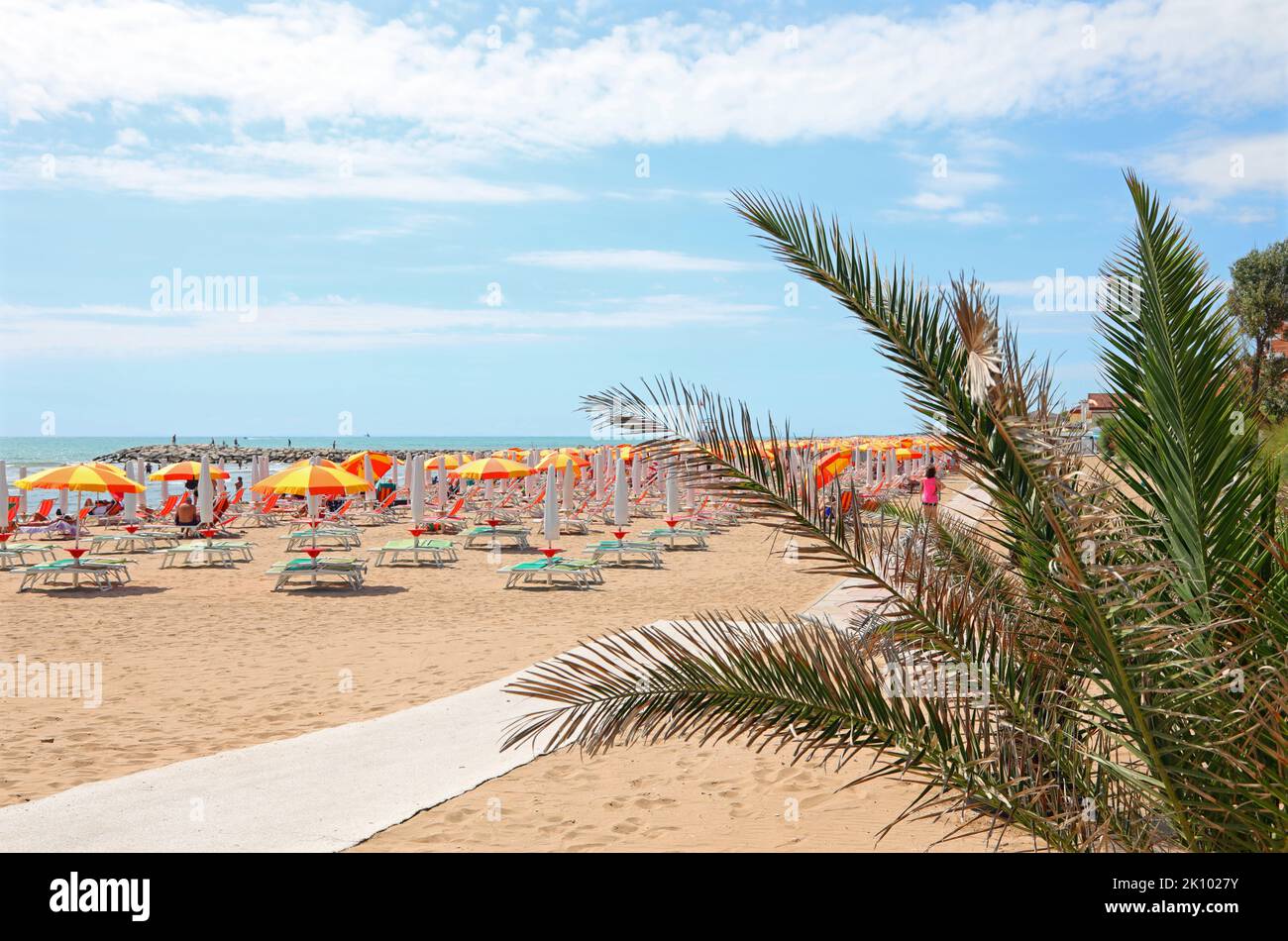 umbrellas and deck chairs without people on the beach near the sea in ...