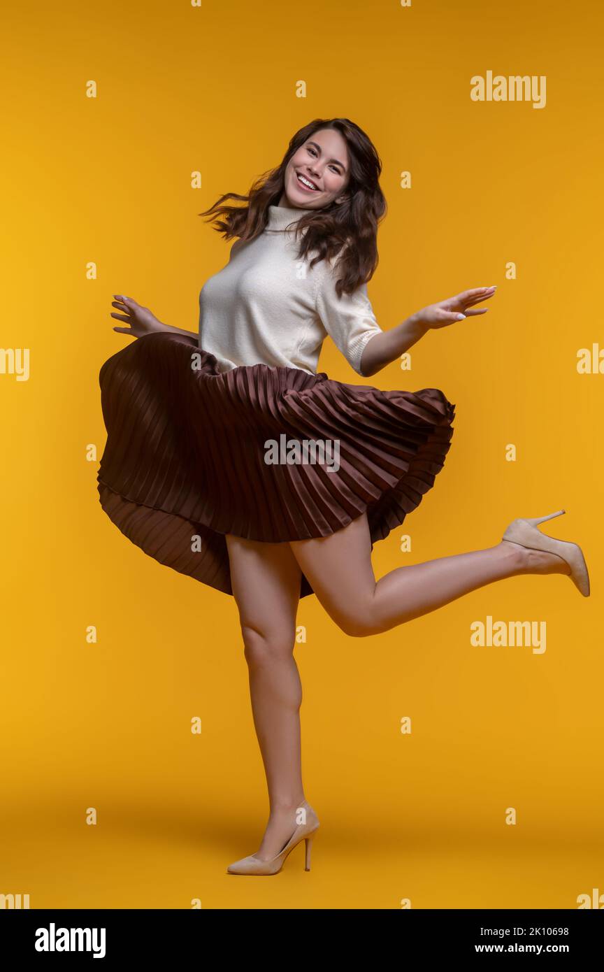 Woman smiling confidently at camera raising her leg back Stock Photo ...