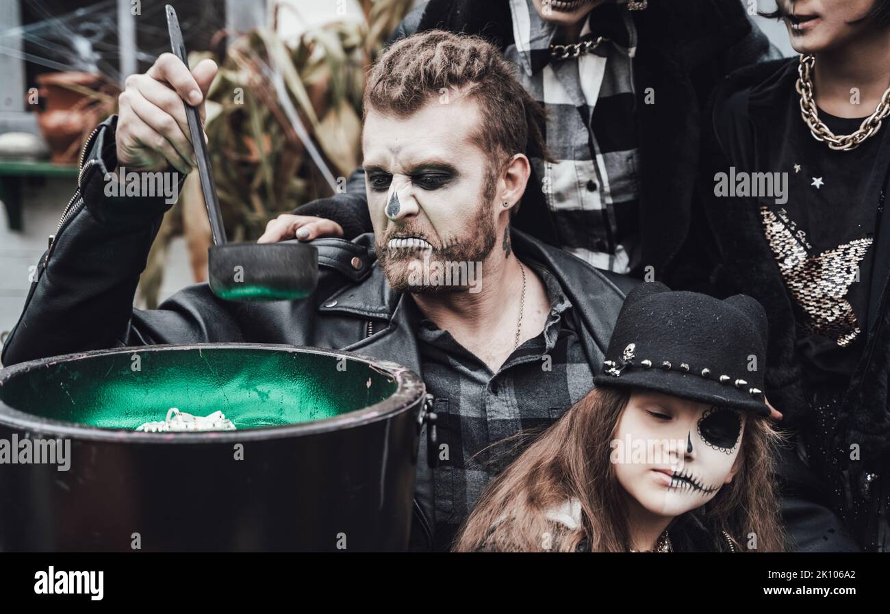 Scary family, mother, father, daughters celebrating halloween. Cauldron ...
