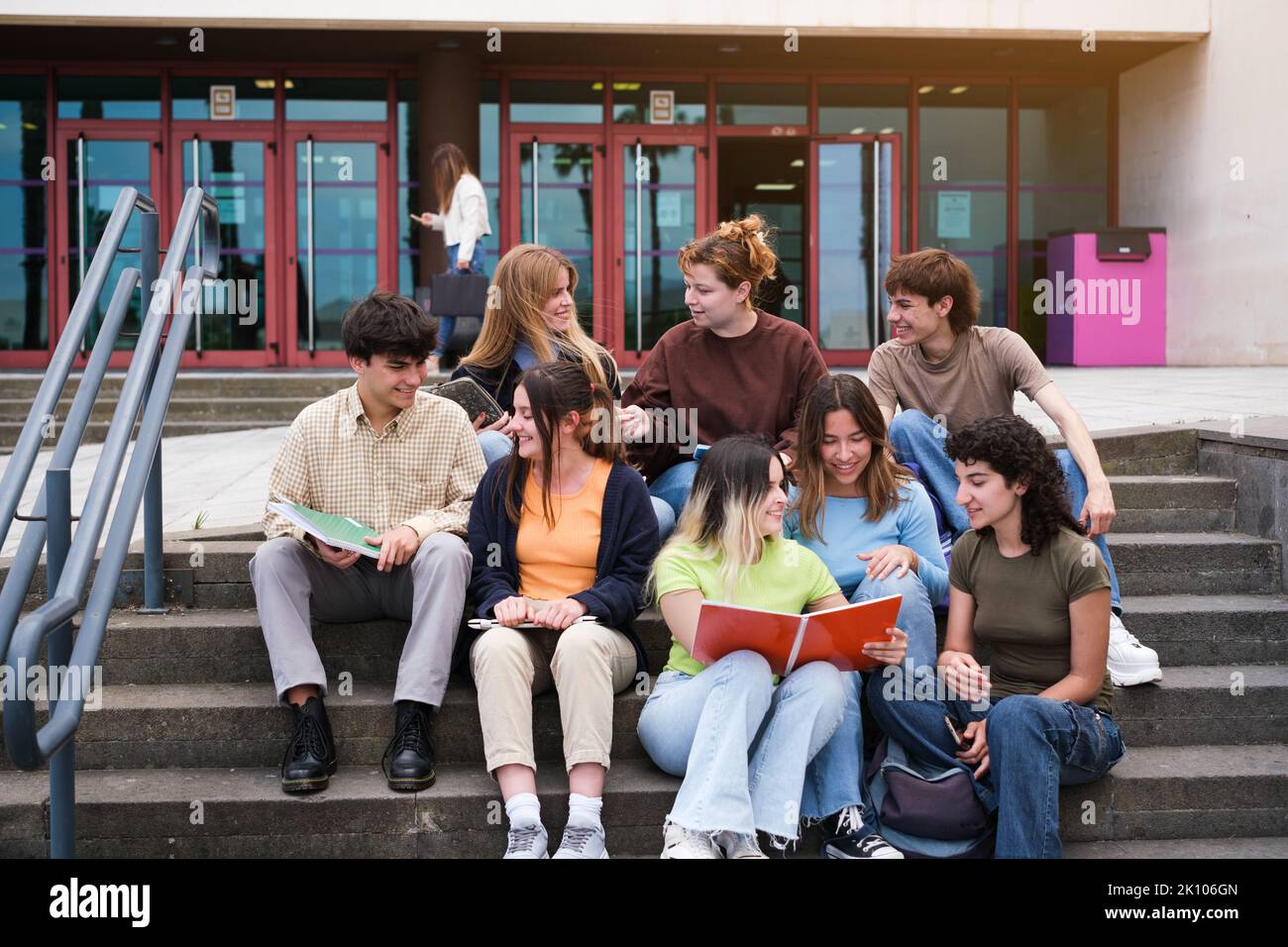 Group of young students sitting on the stairs of the university sharing ...