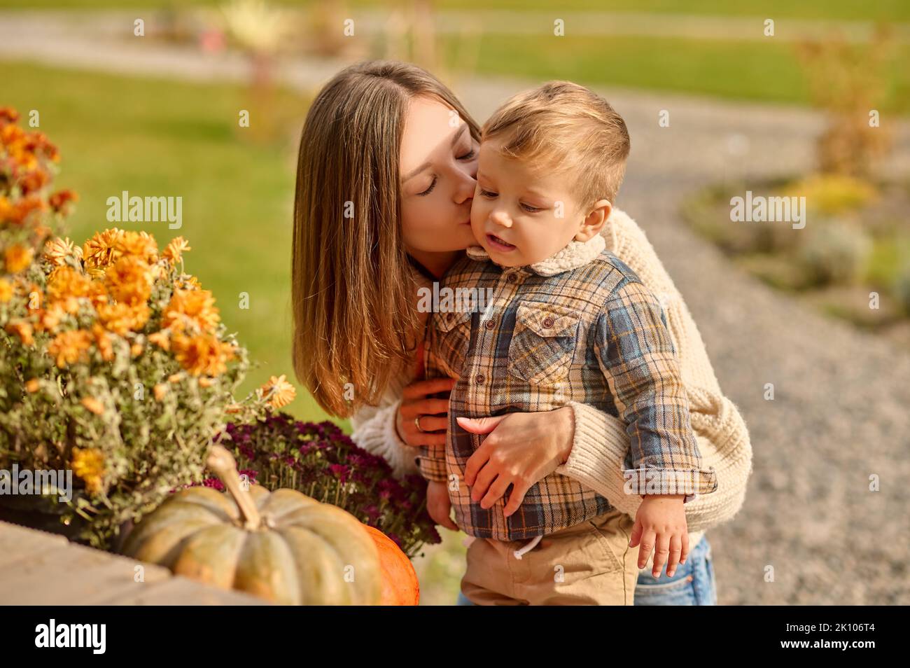 Mother kissing her cute little son outside Stock Photo - Alamy