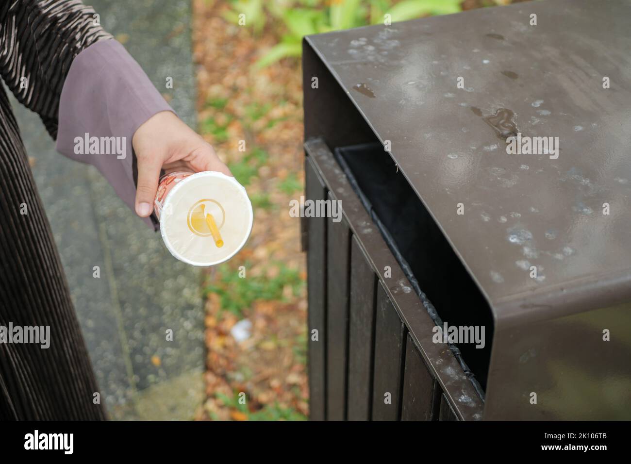 women hand throwing an empty plastic water bottle in the garbage trash ...