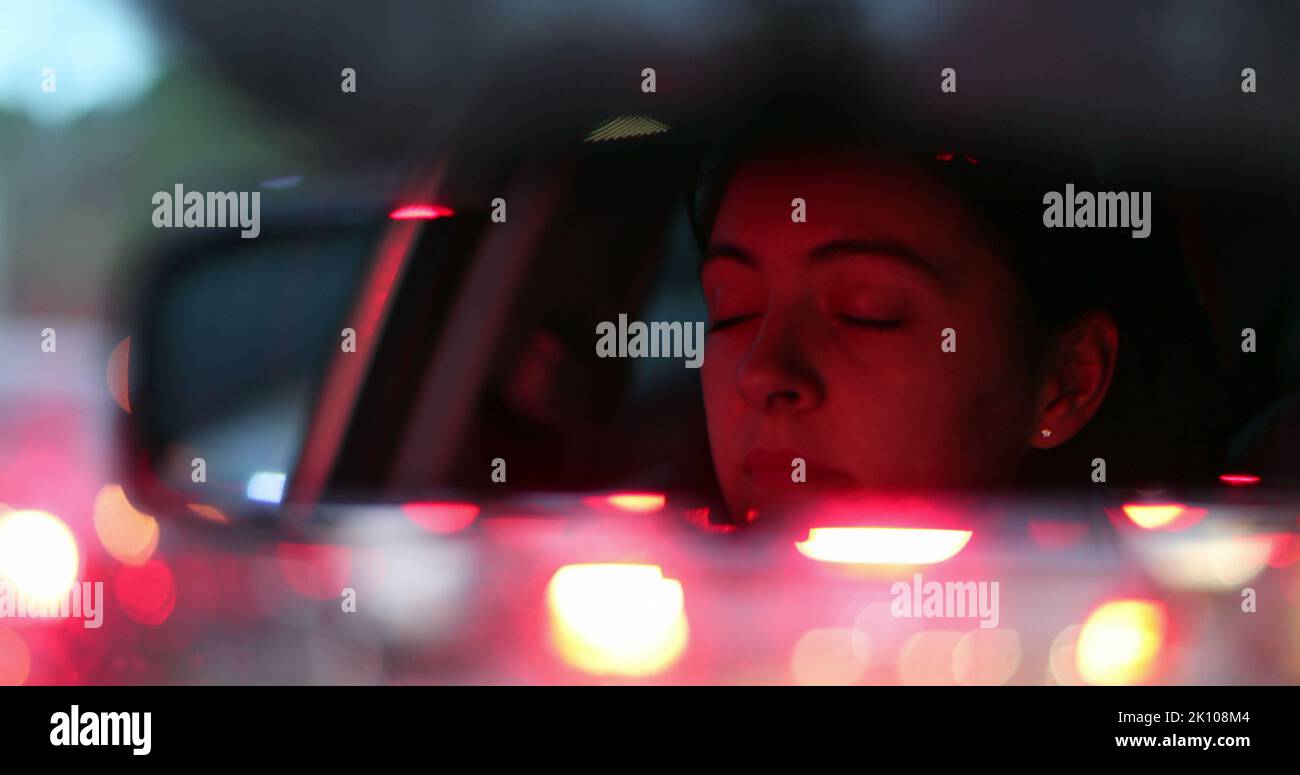 Female driver stuck in traffic closing and opening eyes seen through ...