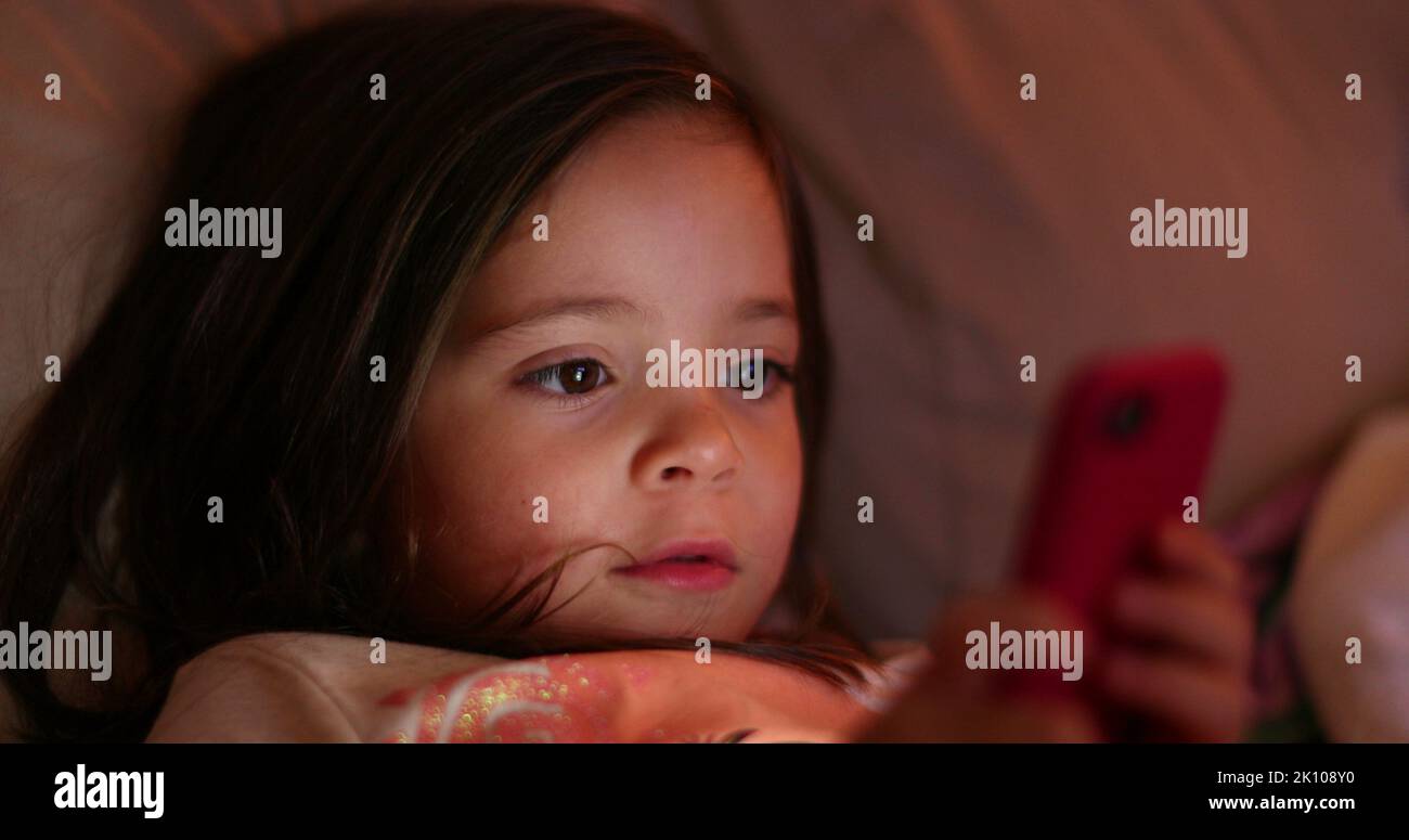 Little girl child using smartphone device, kid playing with cellphone ...