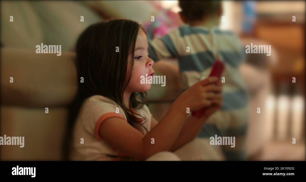 Little girl using smartphone at night. Child staring at cellphone ...