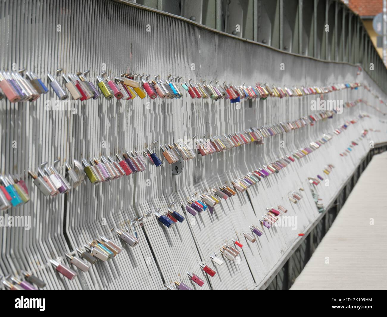 Colorful padlocks hang on the parapet of a bridge as a symbol of the ...