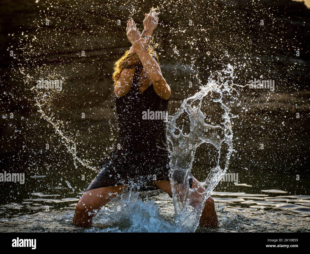 middle-aged woman dancing and throwing water in the air, Maioris beach ...