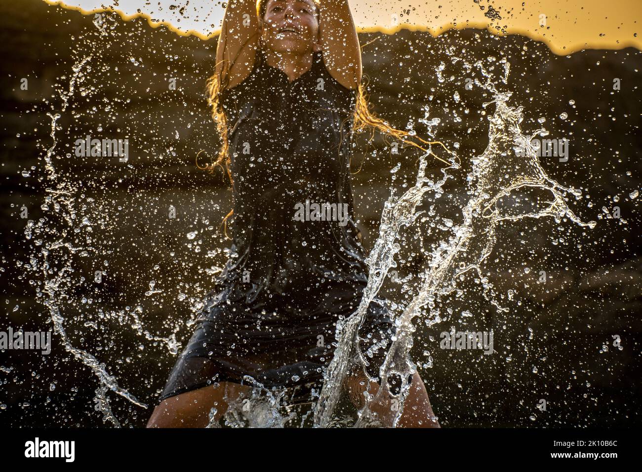 middle-aged woman dancing and throwing water in the air, Maioris beach ...