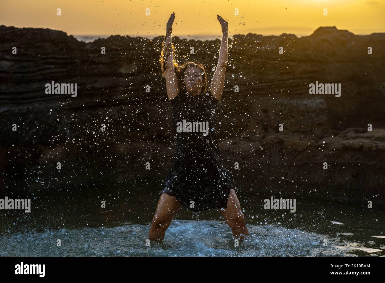 middle-aged woman dancing and throwing water in the air, Maioris beach ...