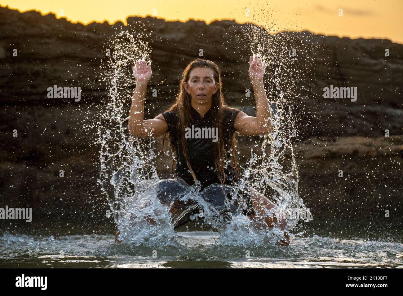 middle-aged woman dancing and throwing water in the air, Maioris beach ...