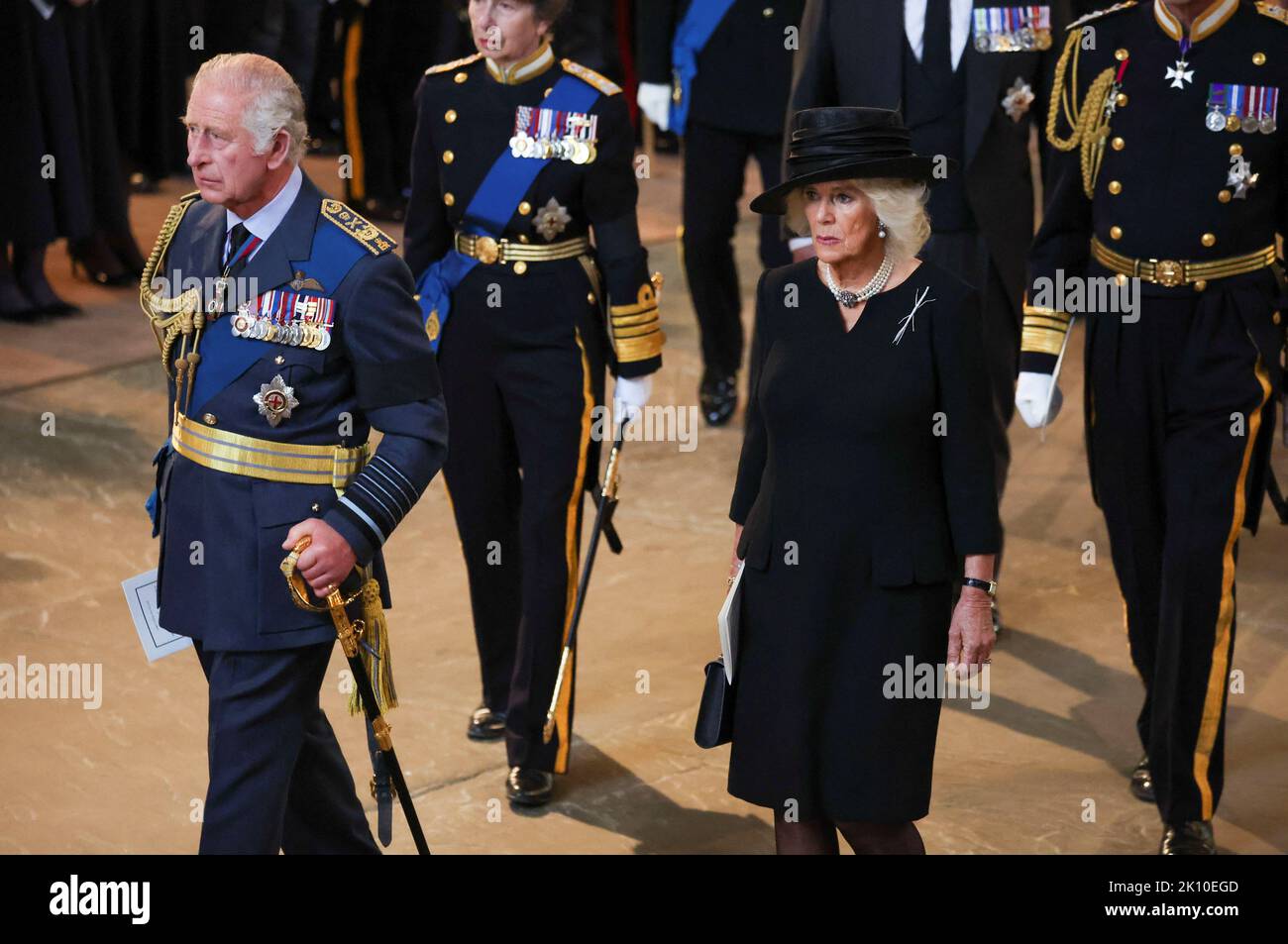 King Charles III and the Queen Consort walk as the coffin of Queen ...