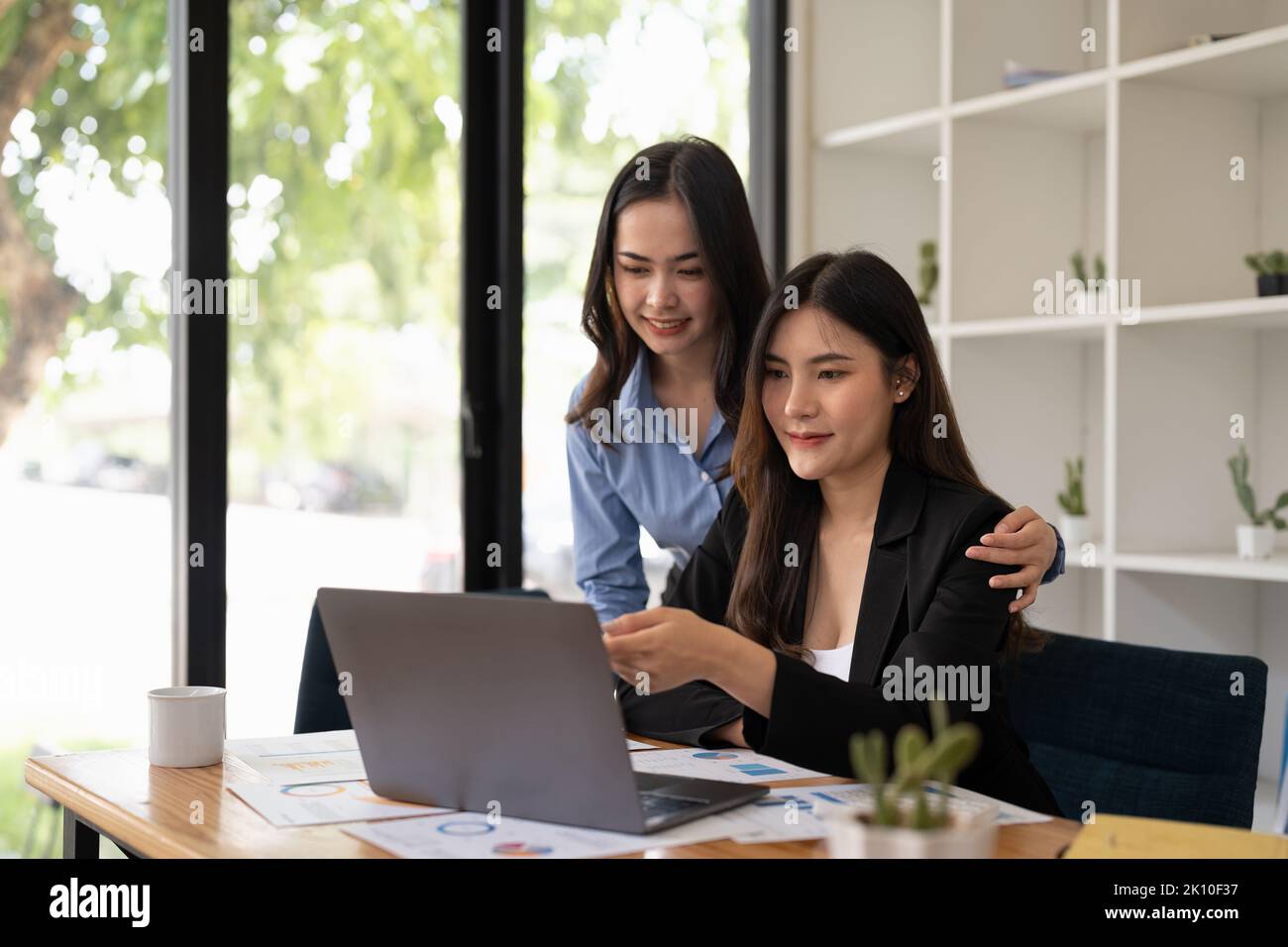 two young asian woman working on laptop computer at office Stock Photo - Alamy