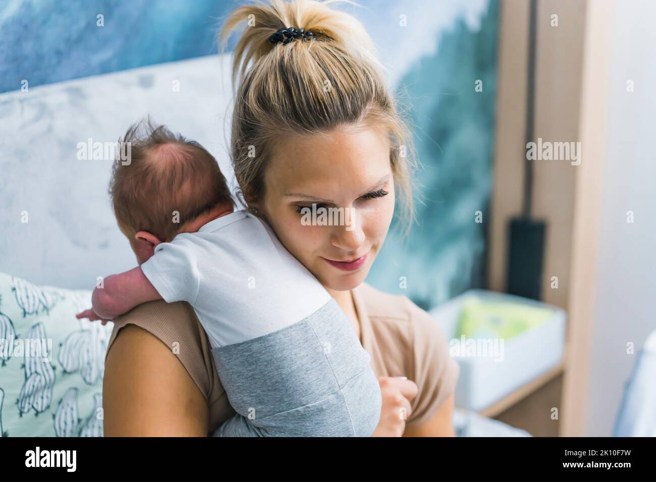 Forming bond between mother and her first-born child. Indoor closeup ...