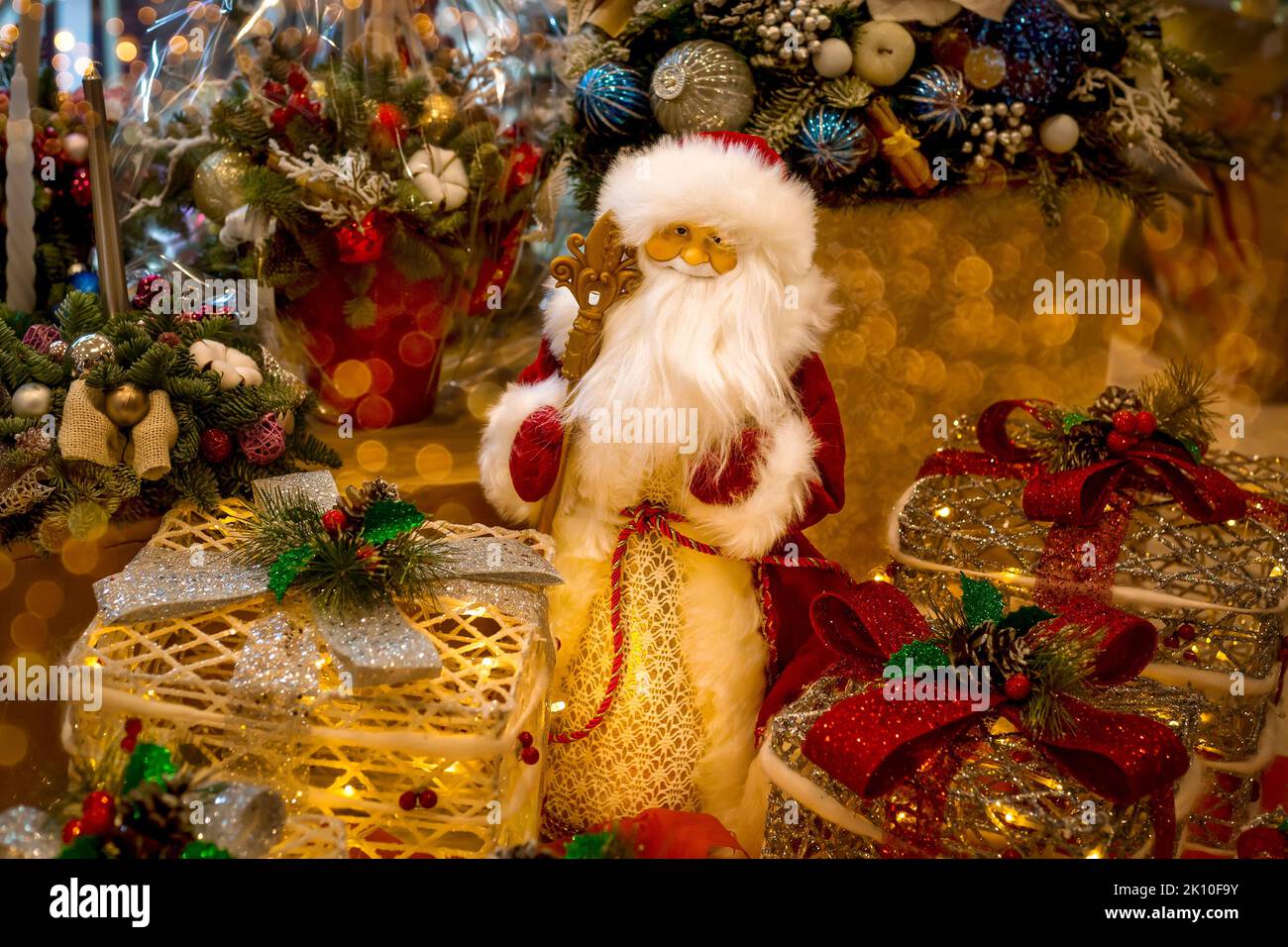 A Santa Claus doll in a red fur coat and hat with a staff and beard and ...