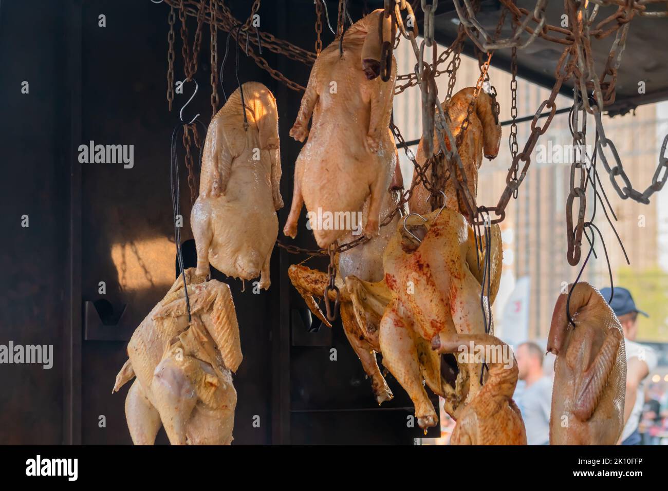 Hanging whole chickens smoking over coals at summer food market Stock ...