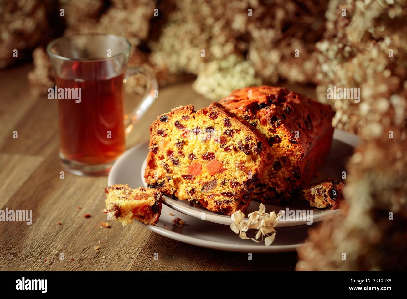 Cake with raisins and candied fruit. Fruit cake and tea on a wooden ...