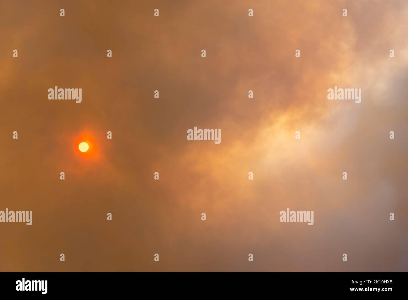 Cloud of smoke from large forest fire passing in front of sun ...