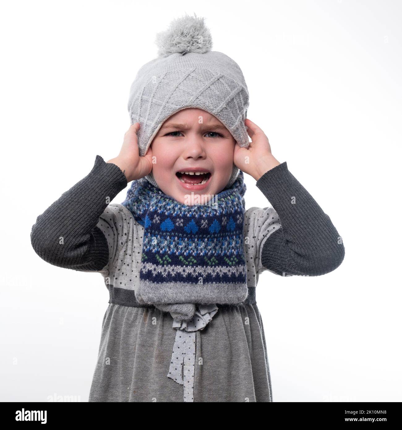 Portrait of a little girl in a hat and scarf on a white background, the ...
