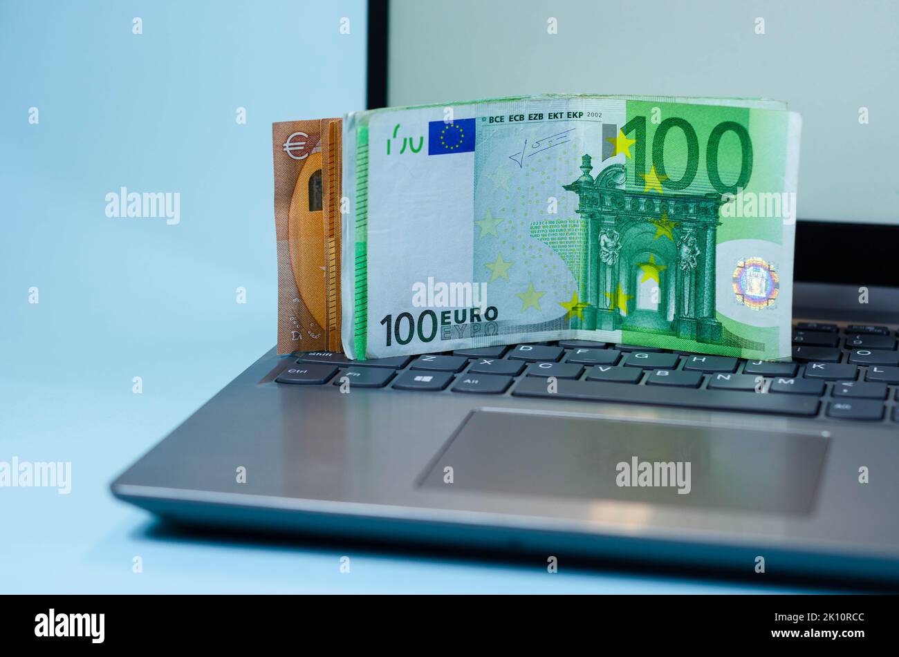 Stack pile of 100 50 Euro bank currency notes above the keyboard of ...