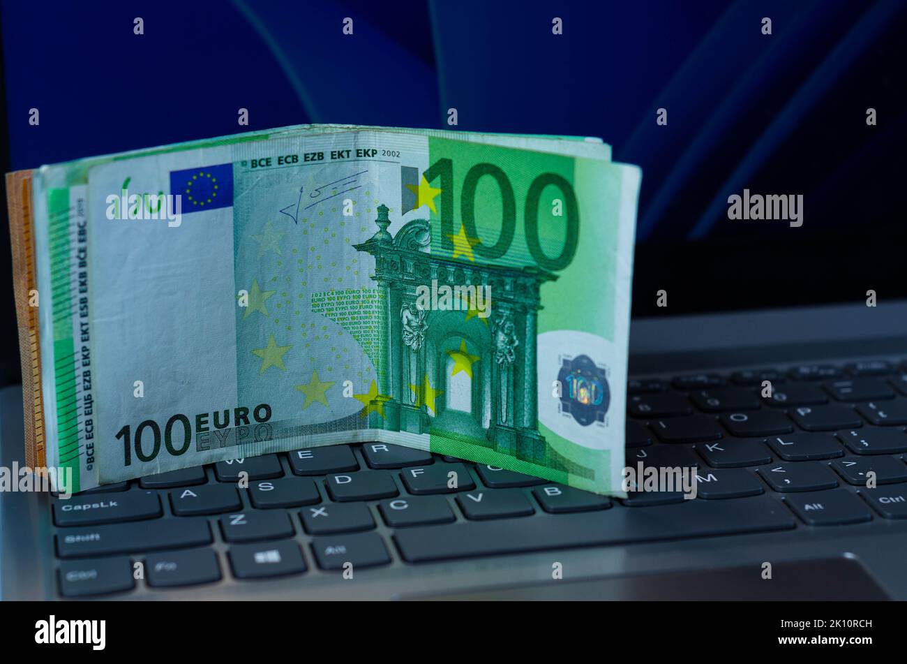 Stack pile of 100 50 Euro bank currency notes above the keyboard of ...