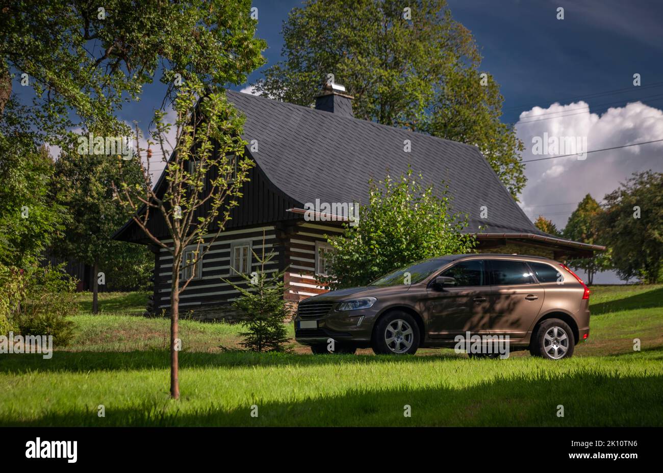 New suv car in summer sunny day with typical wooden village house in ...