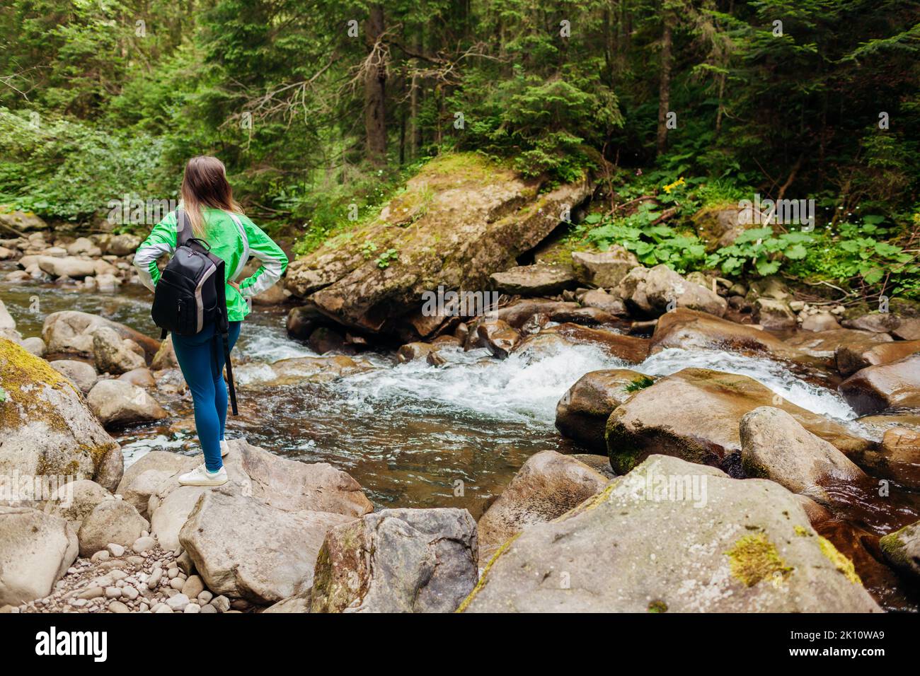 Back view of female traveler hiker with backpack admiring landscape by ...
