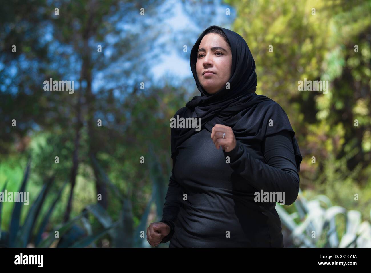 Focused muslim woman wearing hijab running outdoors Stock Photo - Alamy