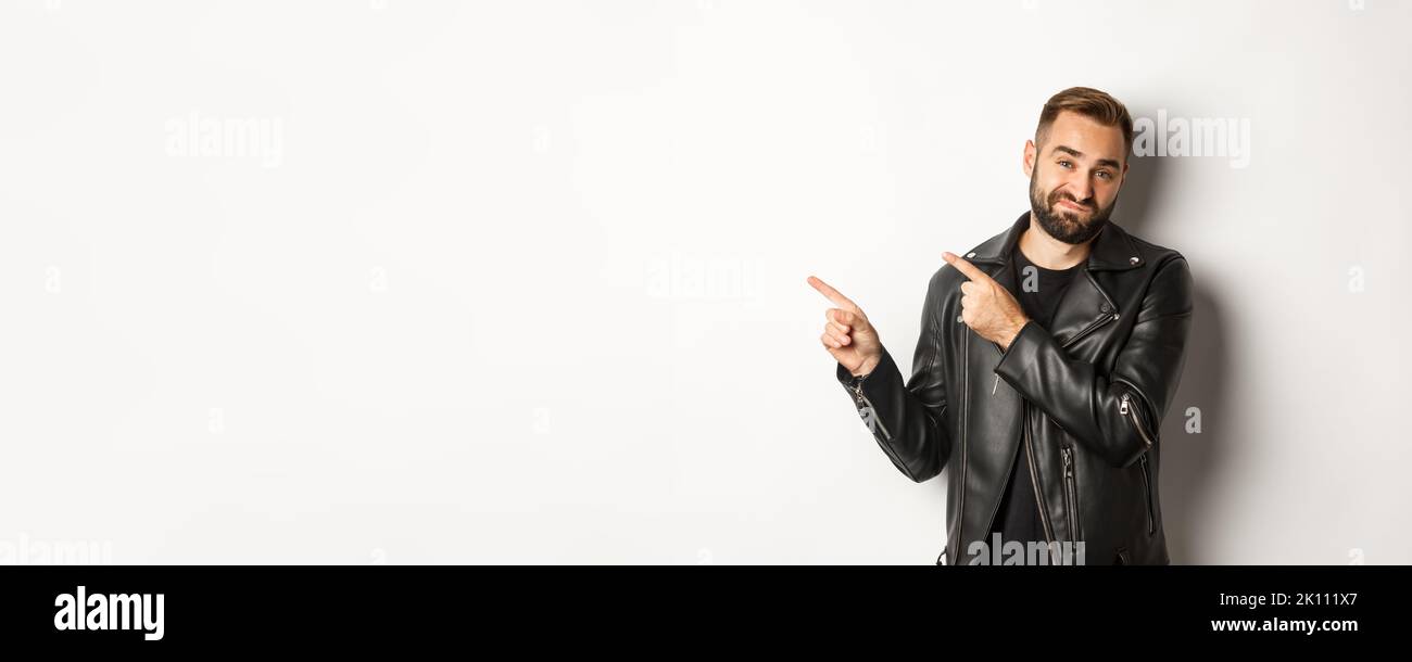 Skeptical and disapleased man in leather jacket, pointing fingers at ...