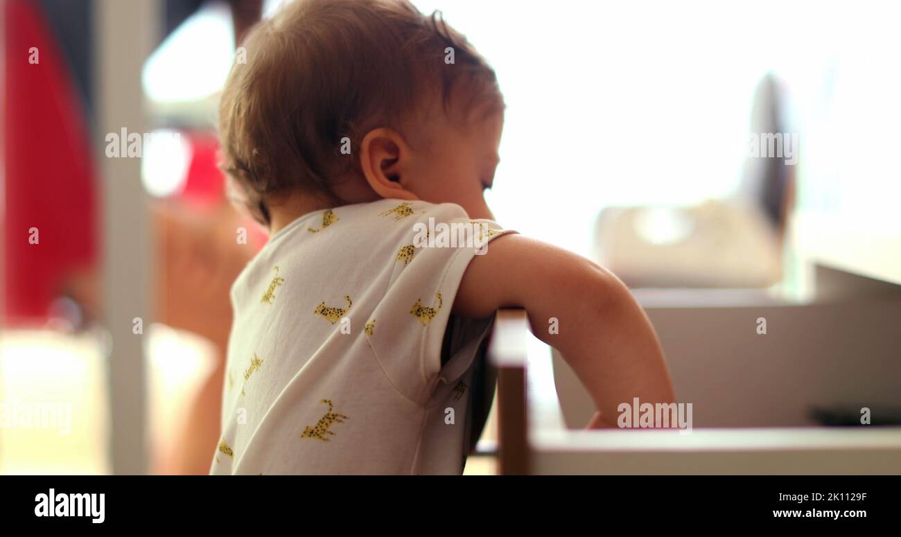 Baby grabbing something from drawer Stock Photo - Alamy