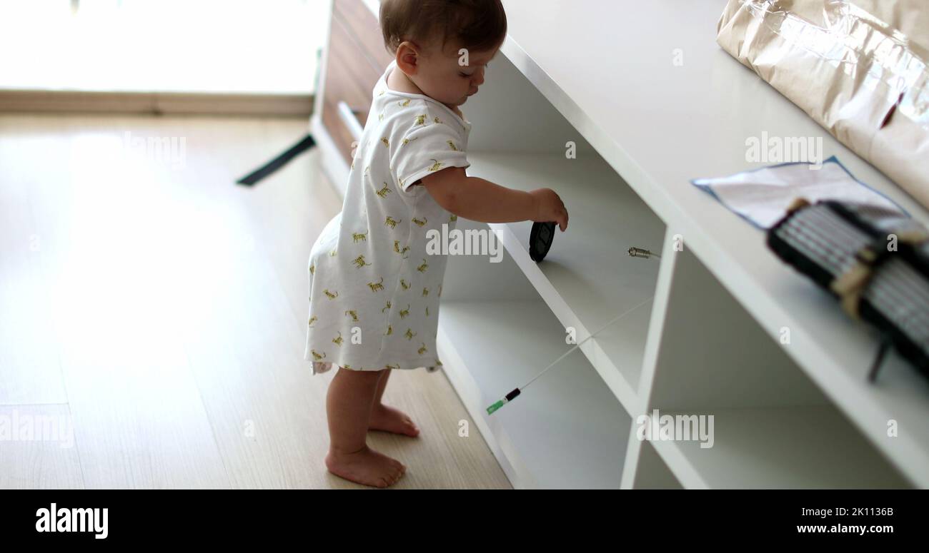 Baby standing leaning on furniture at home living-room. toddler ...