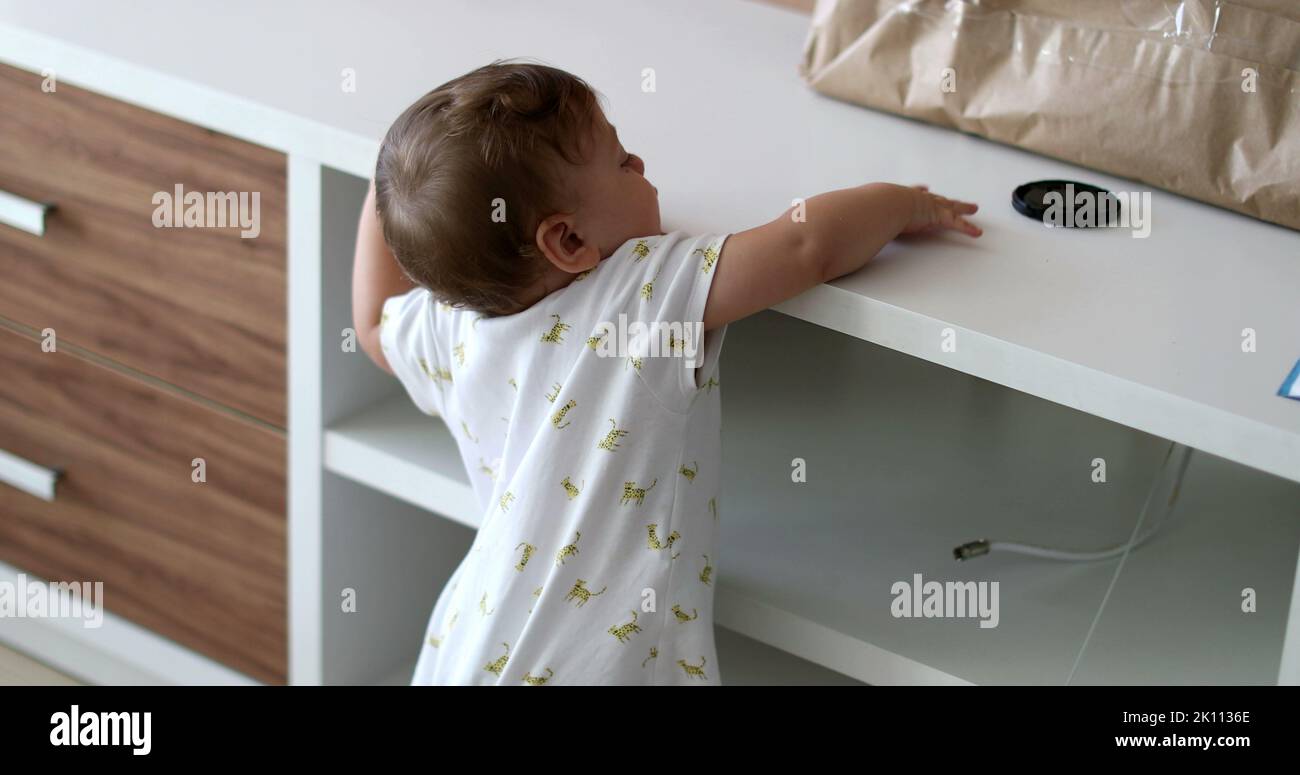 Baby standing on home furniture learning to stand, child infant ...