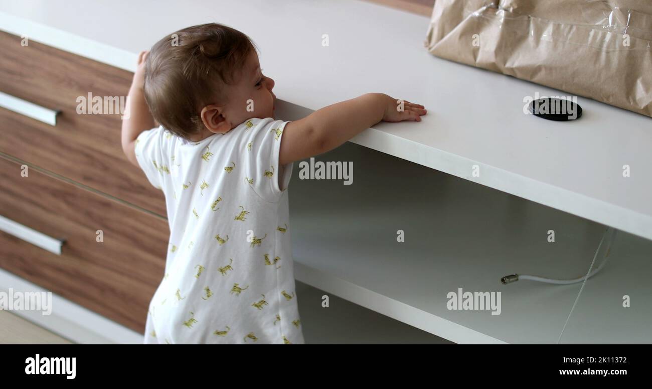 Baby standing on home furniture learning to stand, child infant ...
