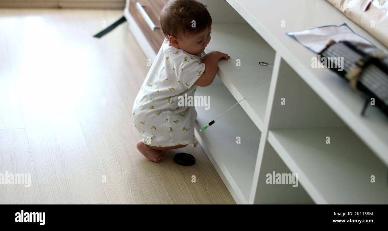 Baby standing leaning on furniture at home living-room. toddler ...
