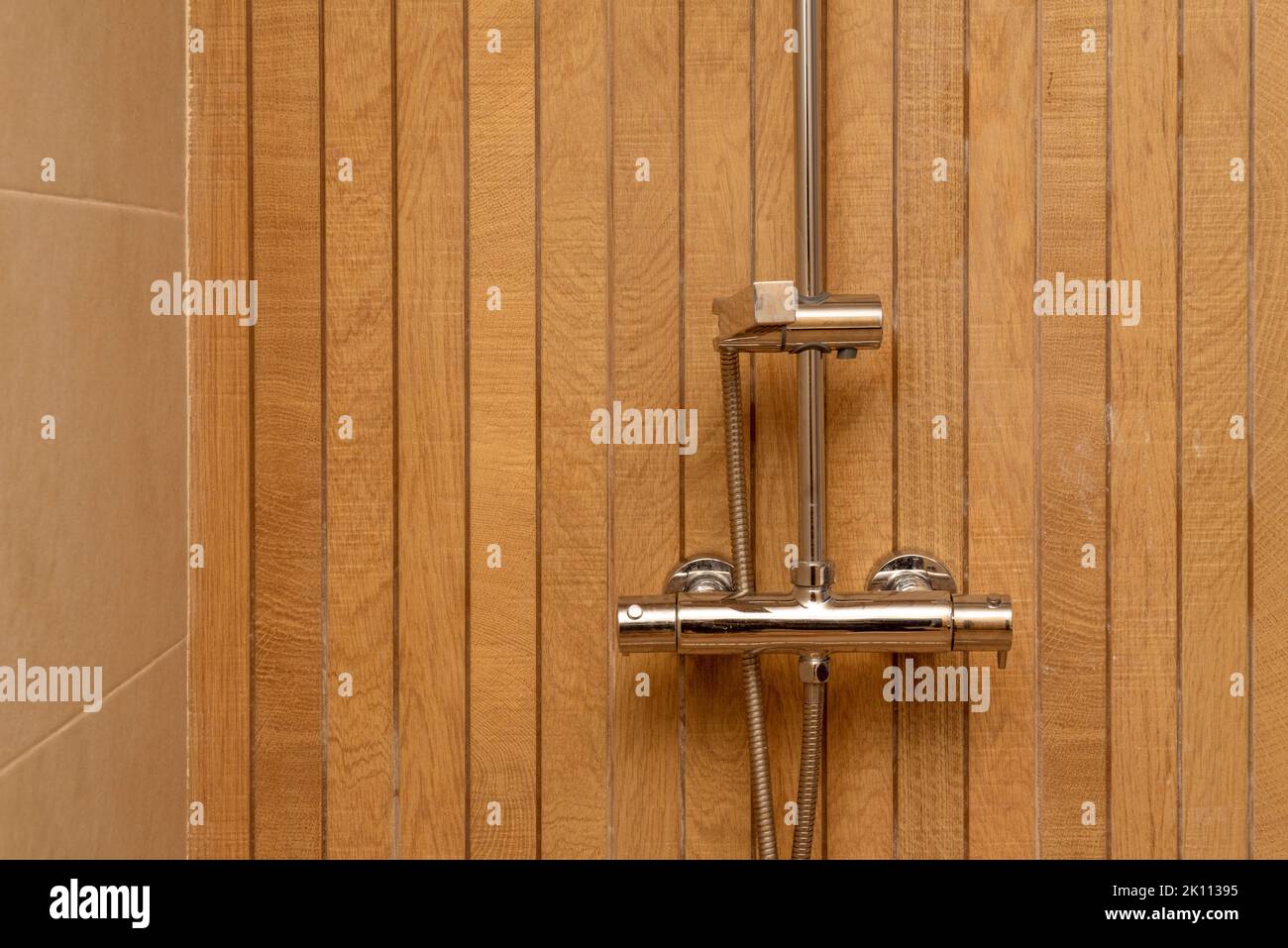 Water flow and temperature taps in a bathroom with wooden wall Stock ...