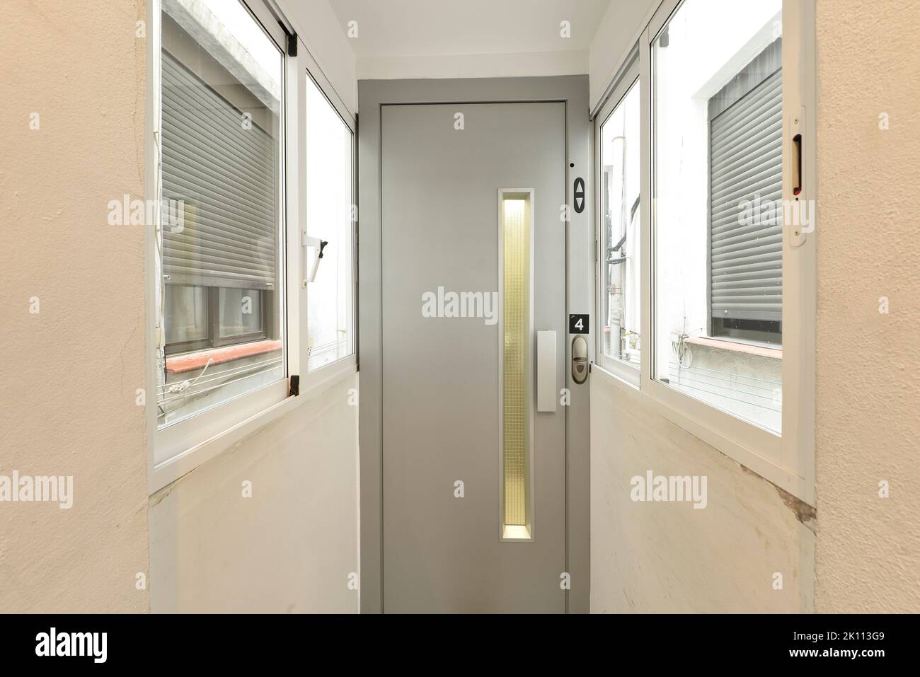 Gray metal elevator door encased between windows Stock Photo - Alamy