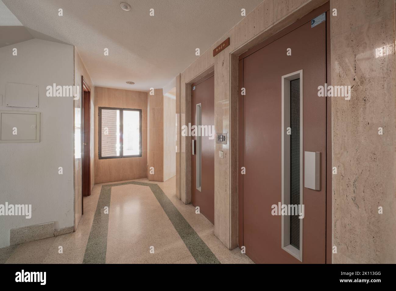 Landing of an apartment building with brown painted metal elevator ...