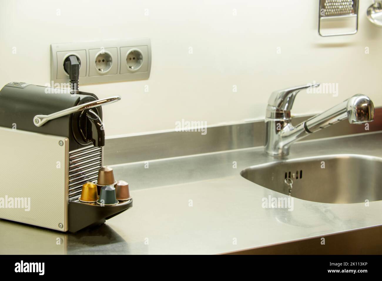 Metal countertop in a kitchen with a capsule coffee machine Stock Photo ...