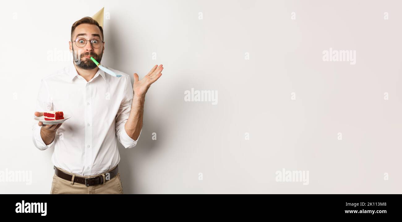 Holidays and celebration. Cheerful man enjoying birthday, blowing party ...