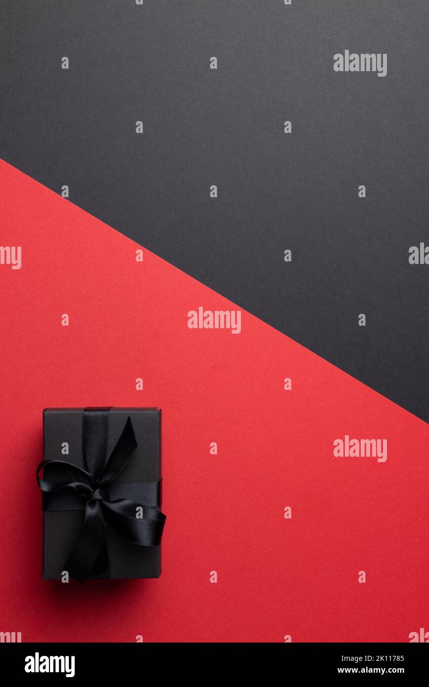 Composition of present with black ribbon on gray and pink background ...