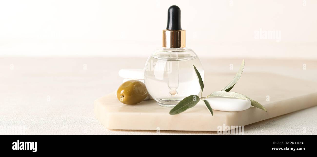 Bottle of essential olive oil on light background with space for text ...