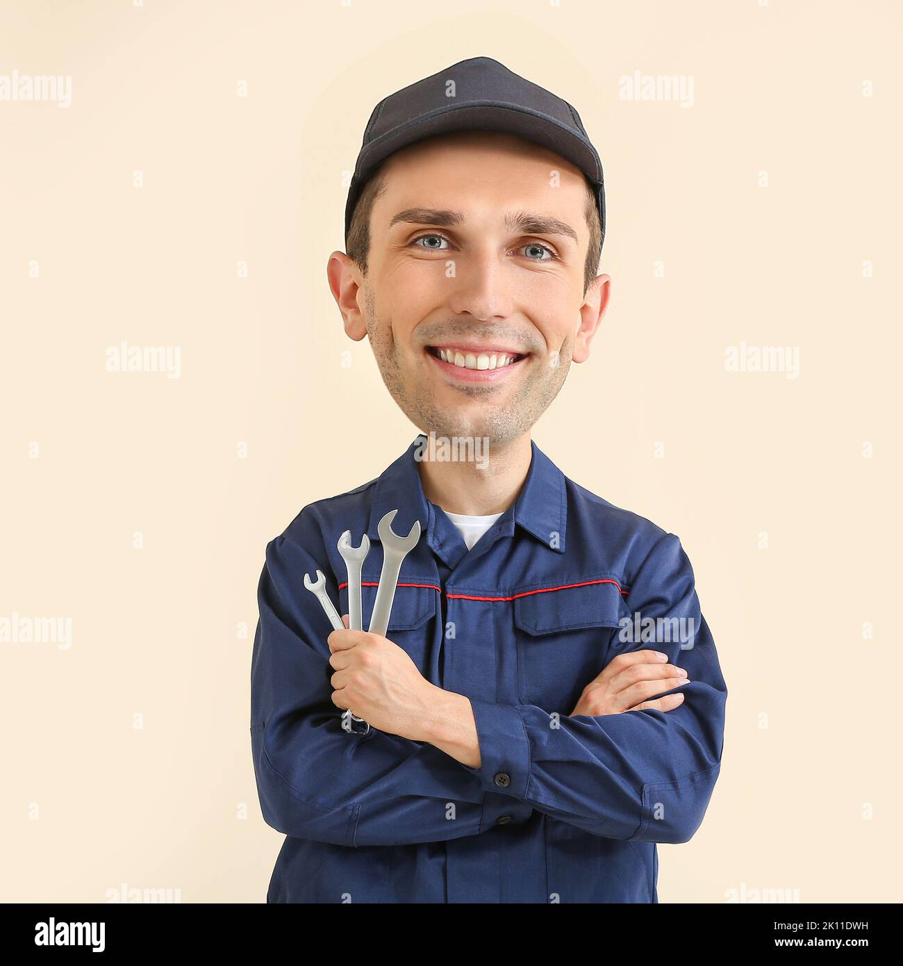 Funny car mechanic with big head on light beige background Stock Photo ...