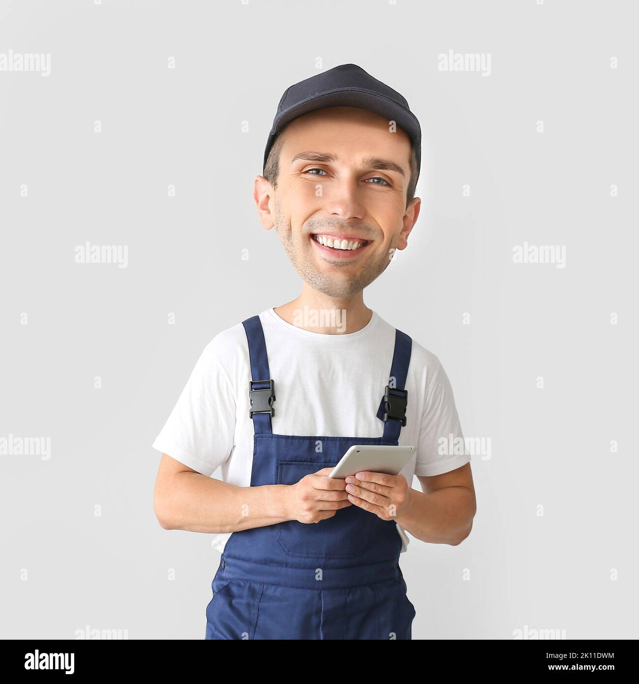 Funny car mechanic with big head and tablet computer on light ...