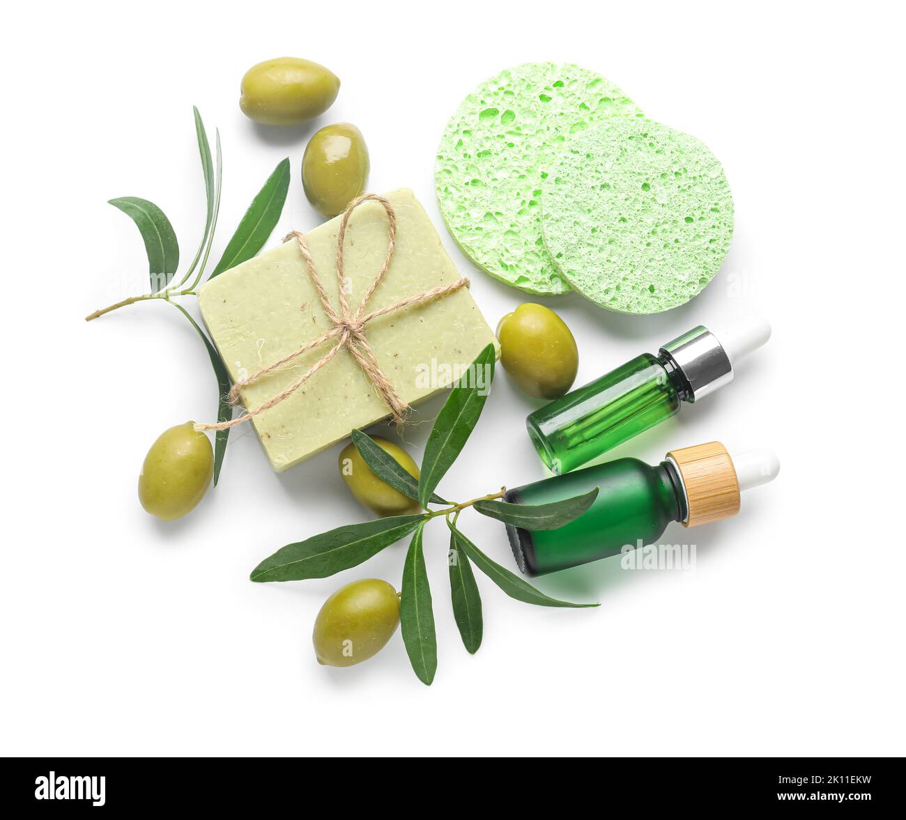 Bottles of essential oil, soap, makeup sponges and green olives on ...