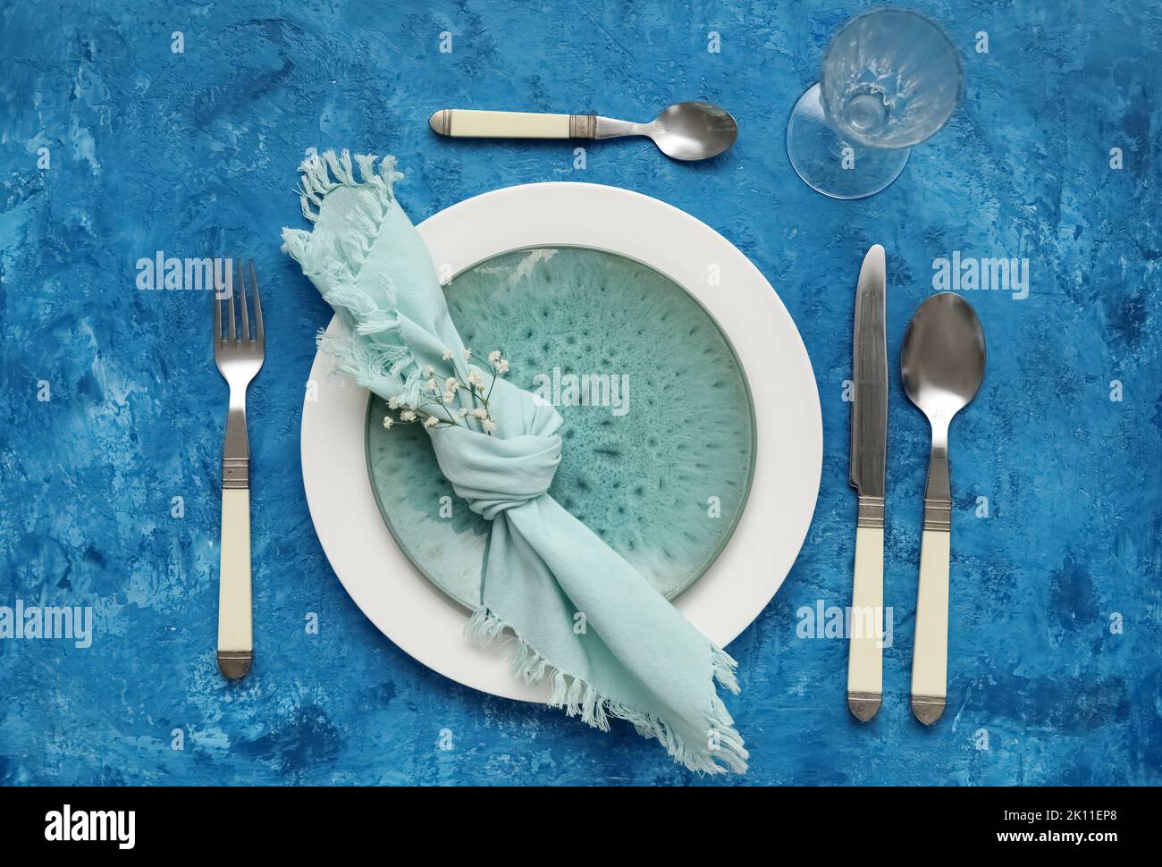 Table setting decorated with gypsophila flowers on blue background ...