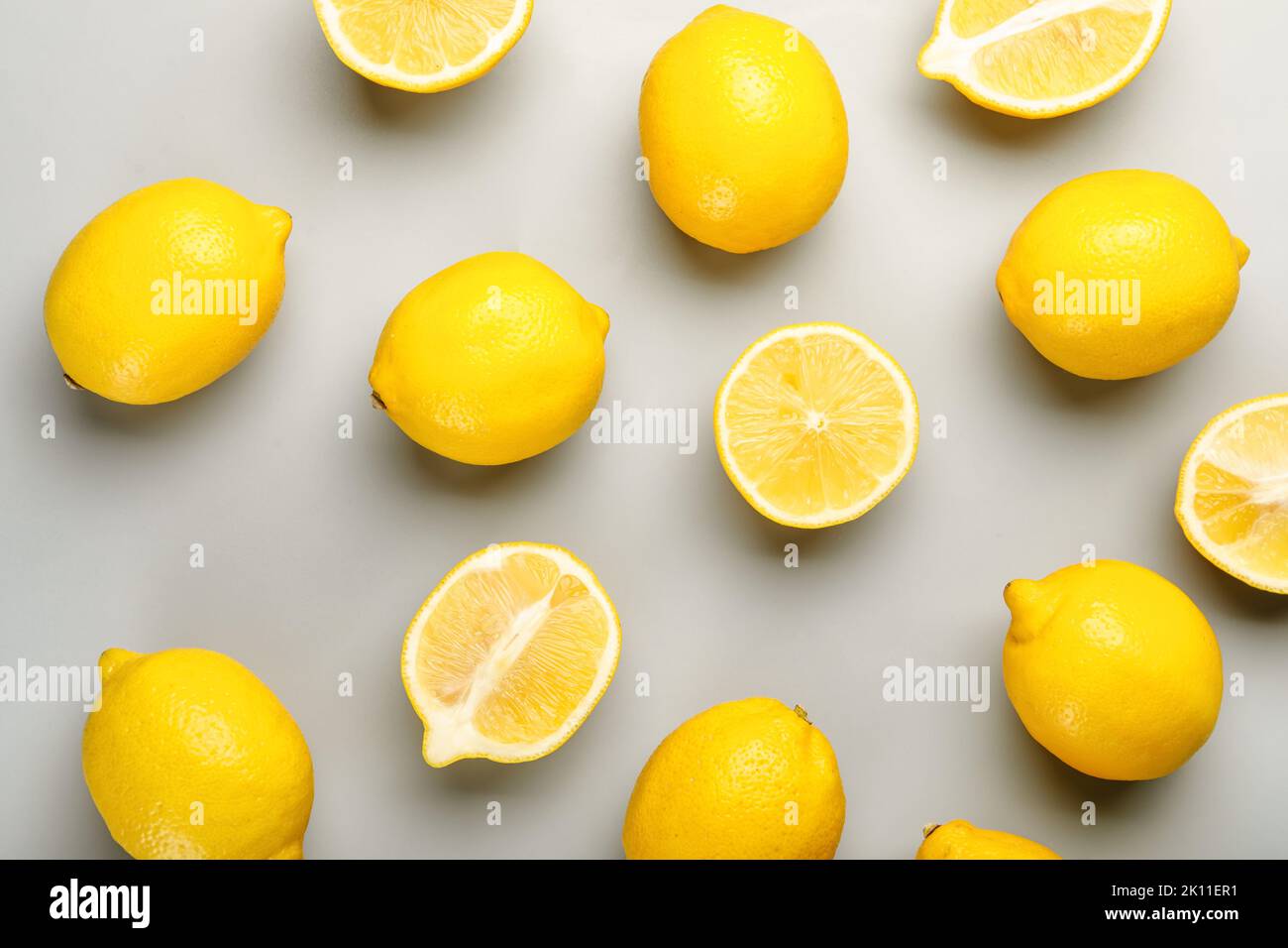 Whole and cut lemons on grey background Stock Photo - Alamy