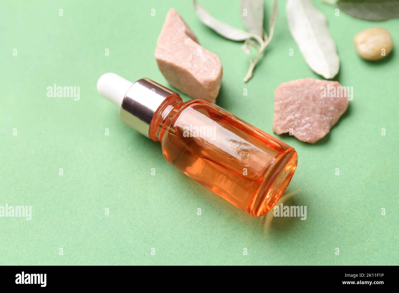 Bottle of essential olive oil on green background, closeup Stock Photo ...